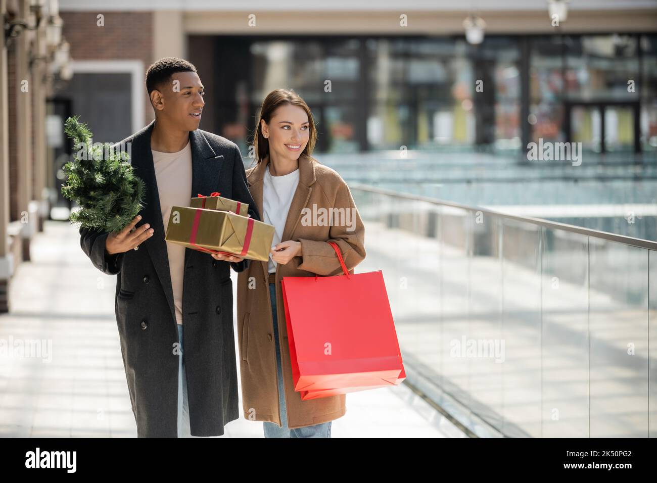 fashionable multiethnic couple with new year presents and small ...