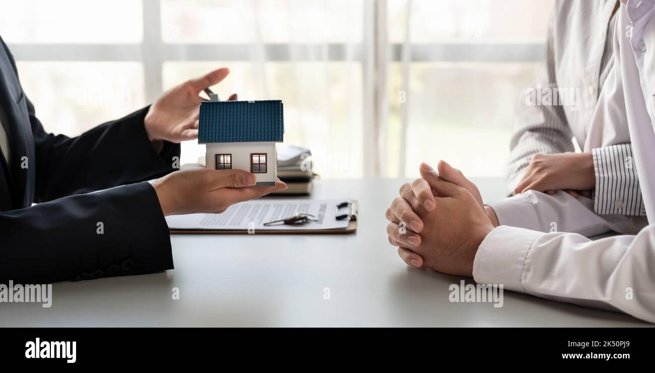 Real estate agent presenting to a couple a project property house model ...