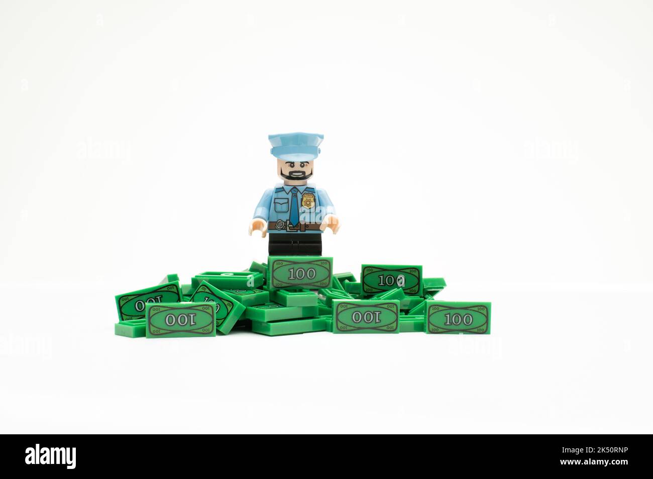 A Lego Police agent standing on a pile of money isolated on white ...