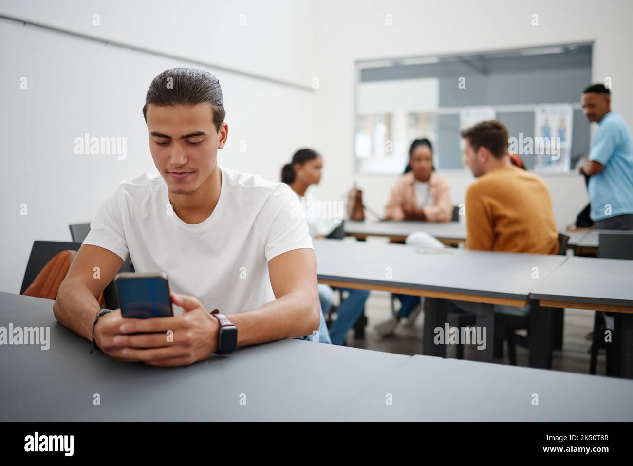 University man and social media on smartphone in lecture auditorium ...