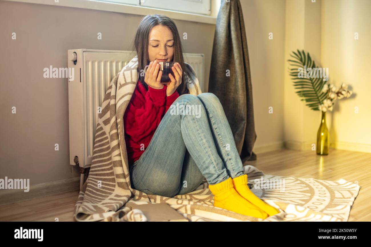 Woman warming herself heater hi-res stock photography and images - Alamy