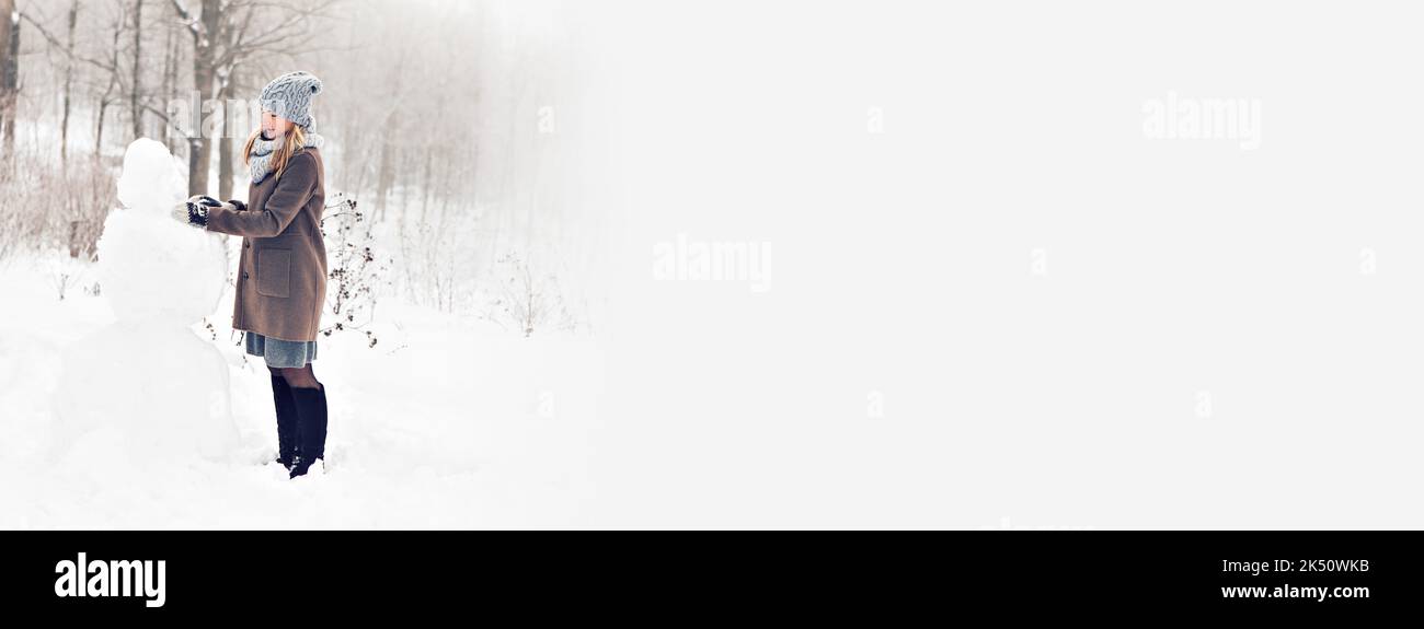 Banner woman making a snowman in winter time copy space and christmas ...