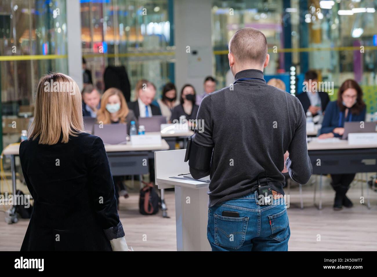 Anonymous man and woman talking during business meeting with colleagues ...