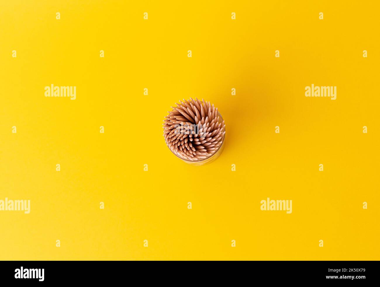 A top view of on a round box of toothpicks yellow background Stock ...