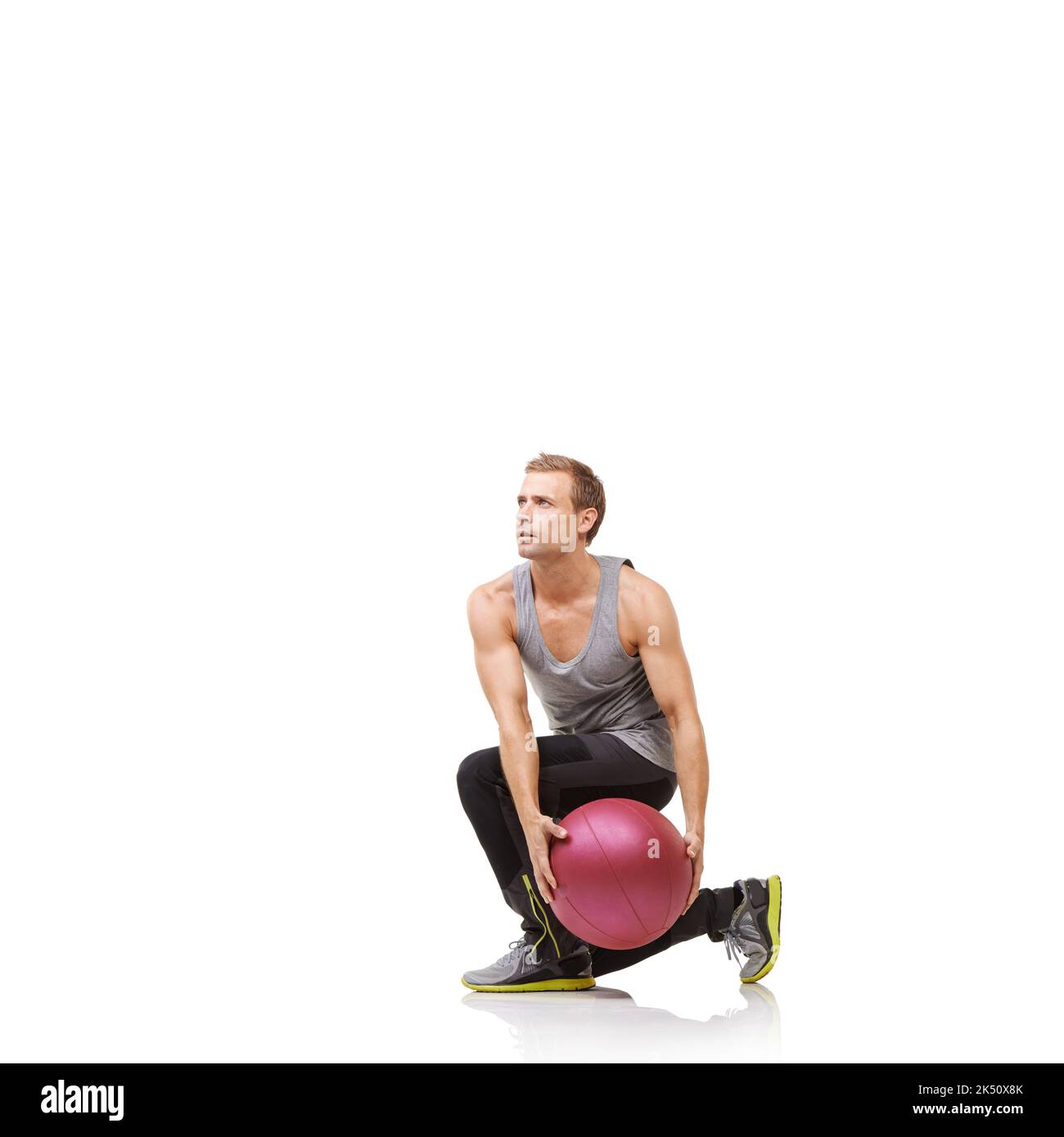 Squats are good for the thighs. A young man working out with a medicine ...