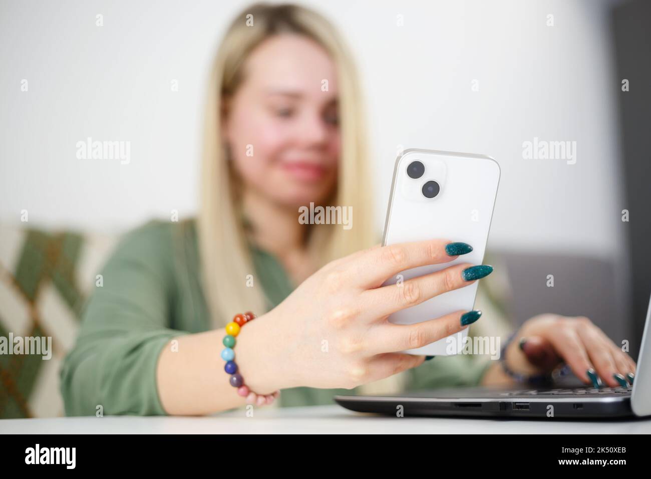 Young woman browsing mobile app on modern smartphone. Blonde female ...