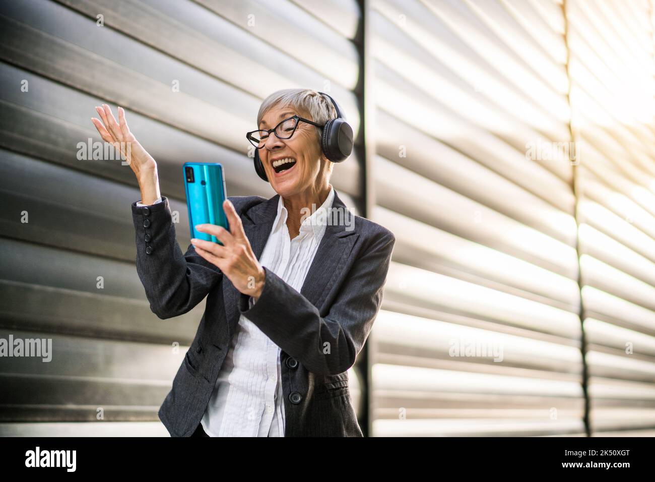 Outdoor portrait of successful senior businesswoman who is listening ...