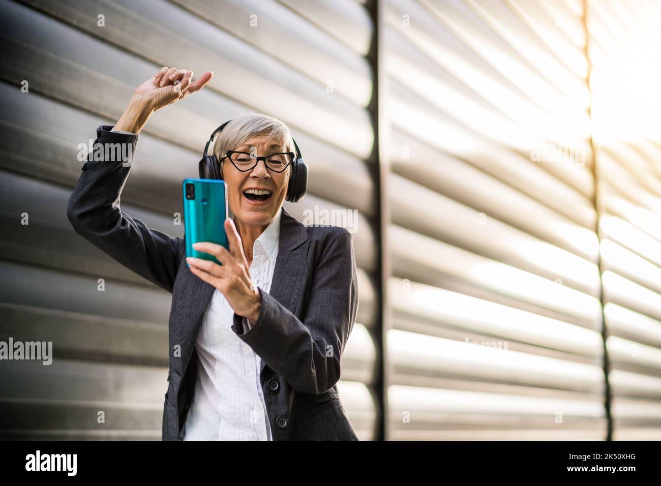 Outdoor portrait of successful senior businesswoman who is listening ...
