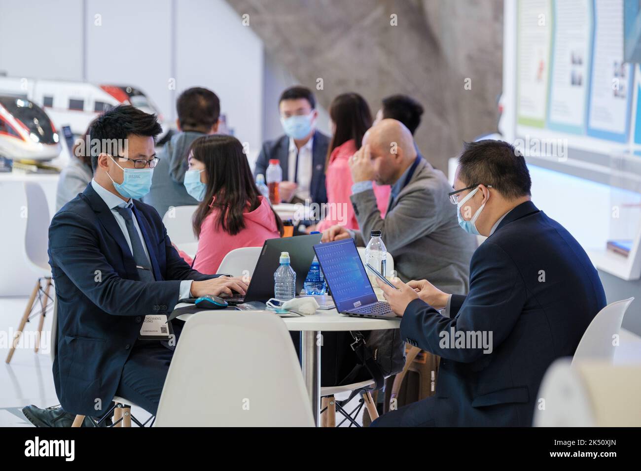 Entrepreneurs working at tables in modern hall Stock Photo - Alamy