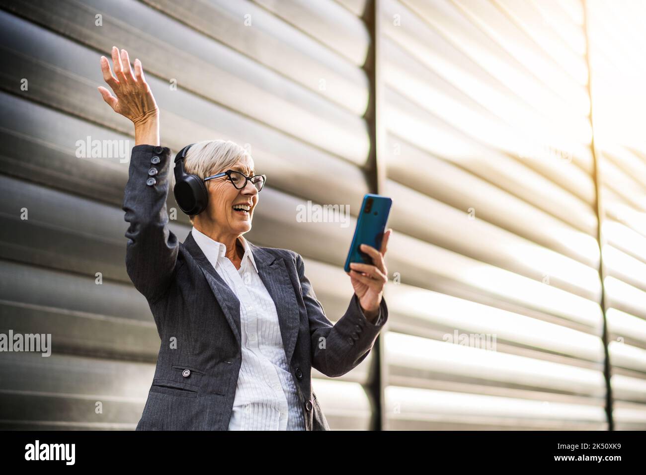 Outdoor portrait of successful senior businesswoman who is listening ...