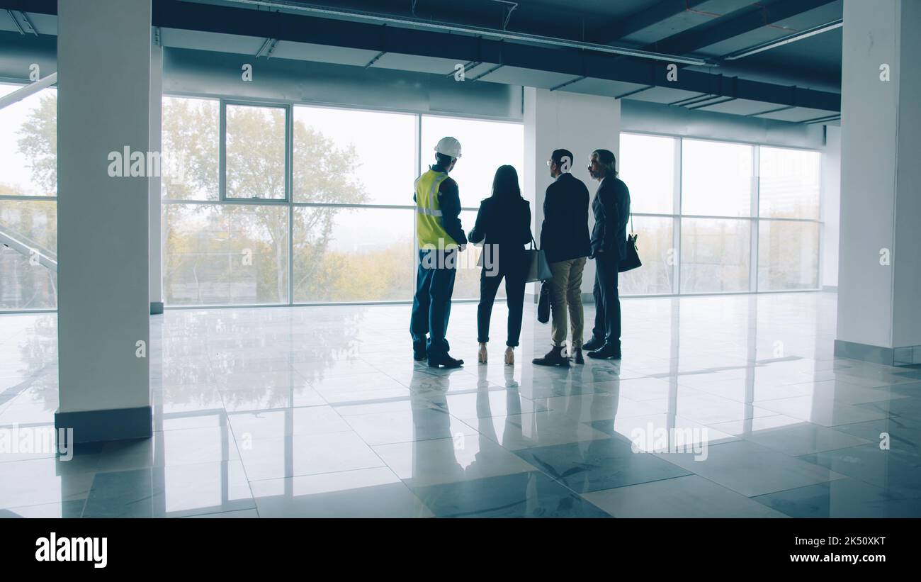 Diverse group of businesspeople standing inside newly constructed ...