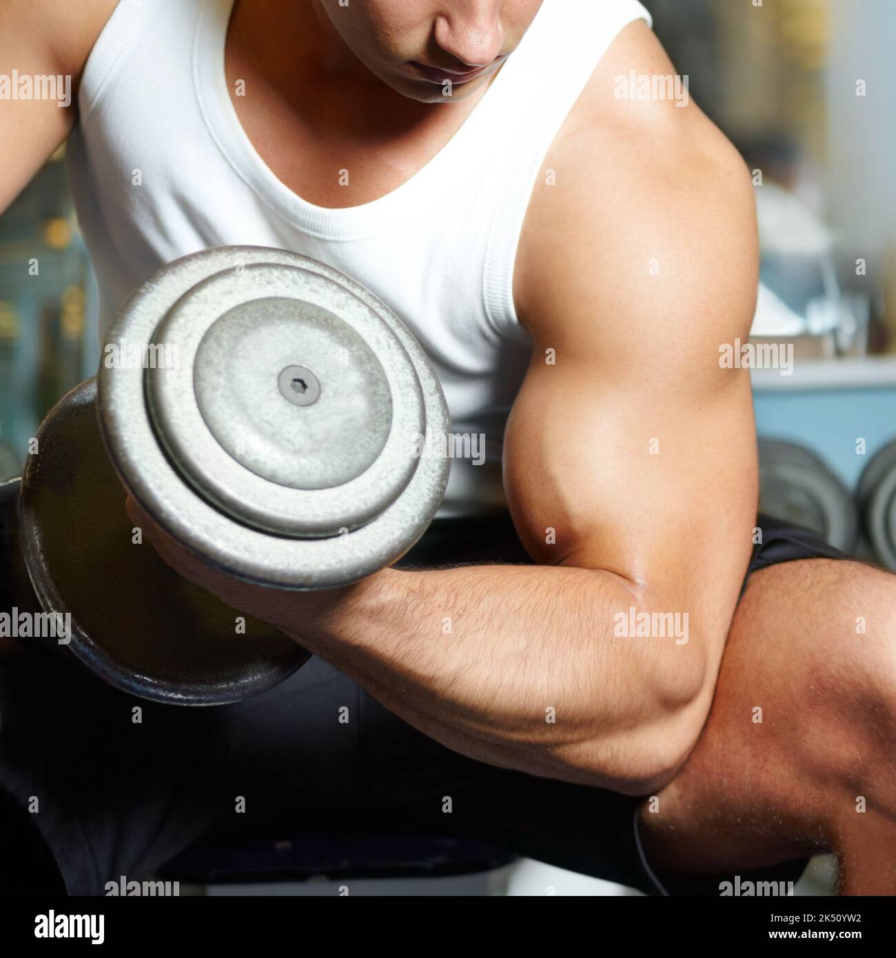 Feel the burn on those biceps. a muscular young man working out in the ...