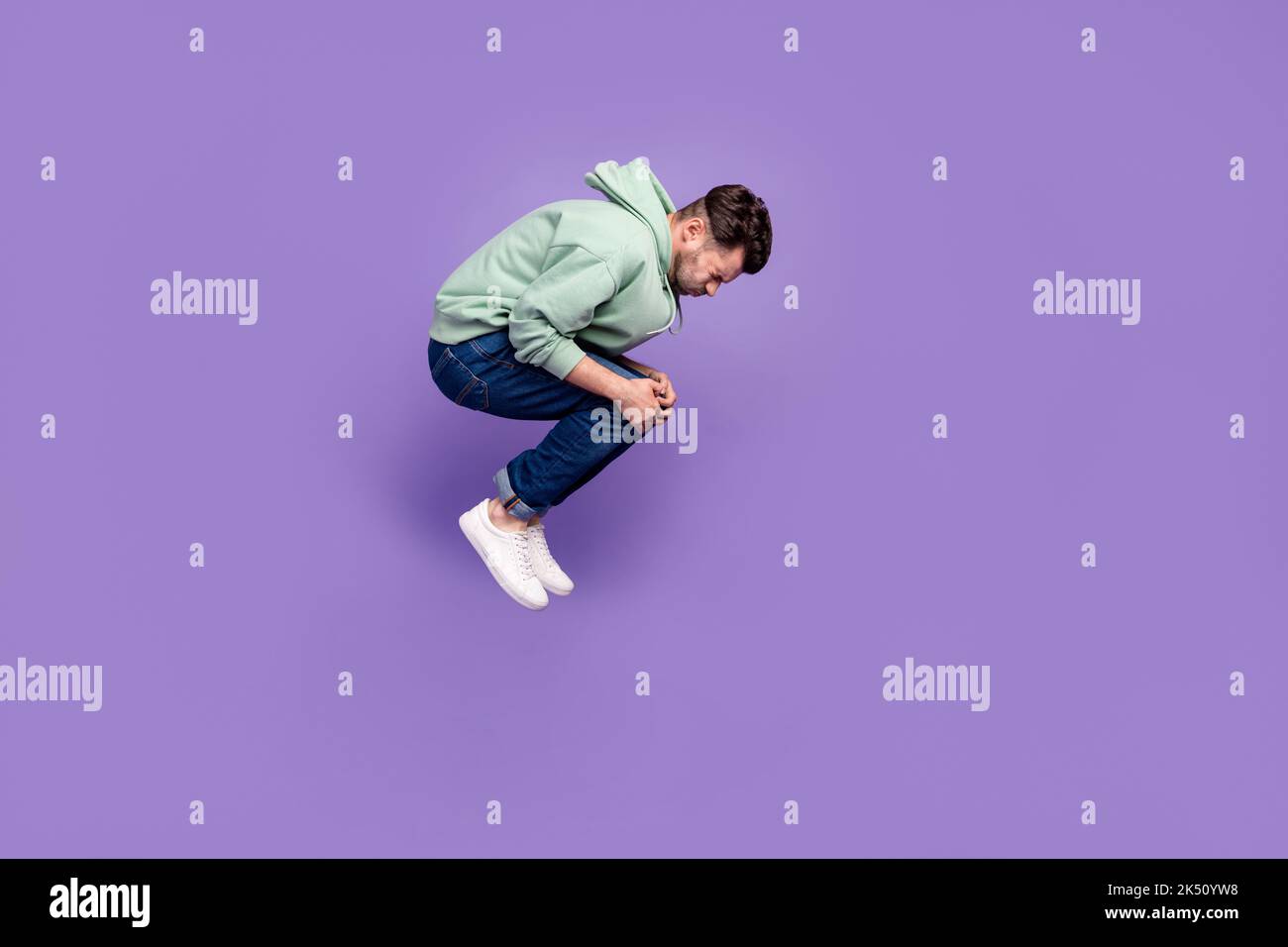 Full size profile photo of falling young man hands hold knees isolated ...