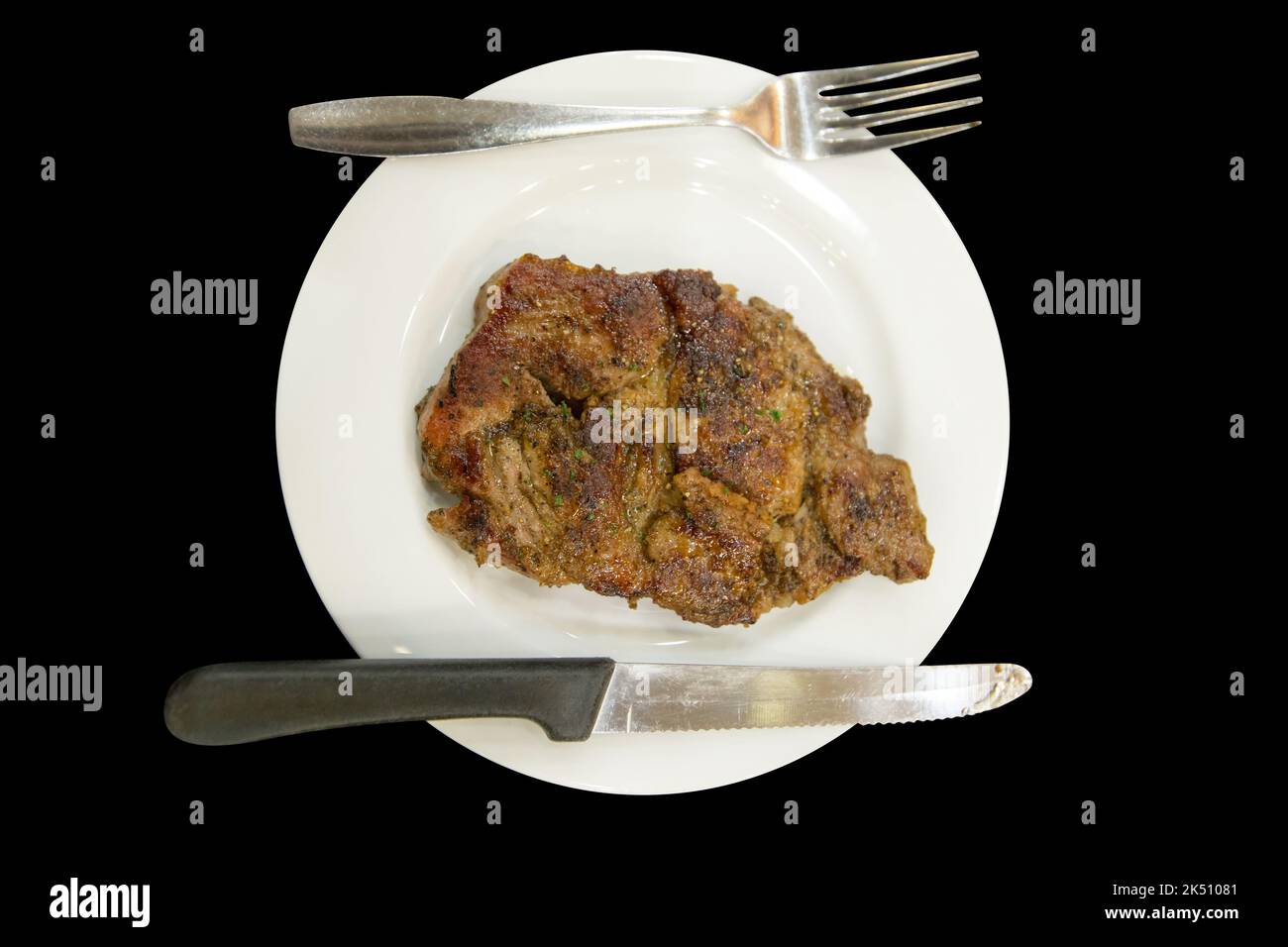 Die cut of grilled pork chop with knife and fork, on black isolated ...