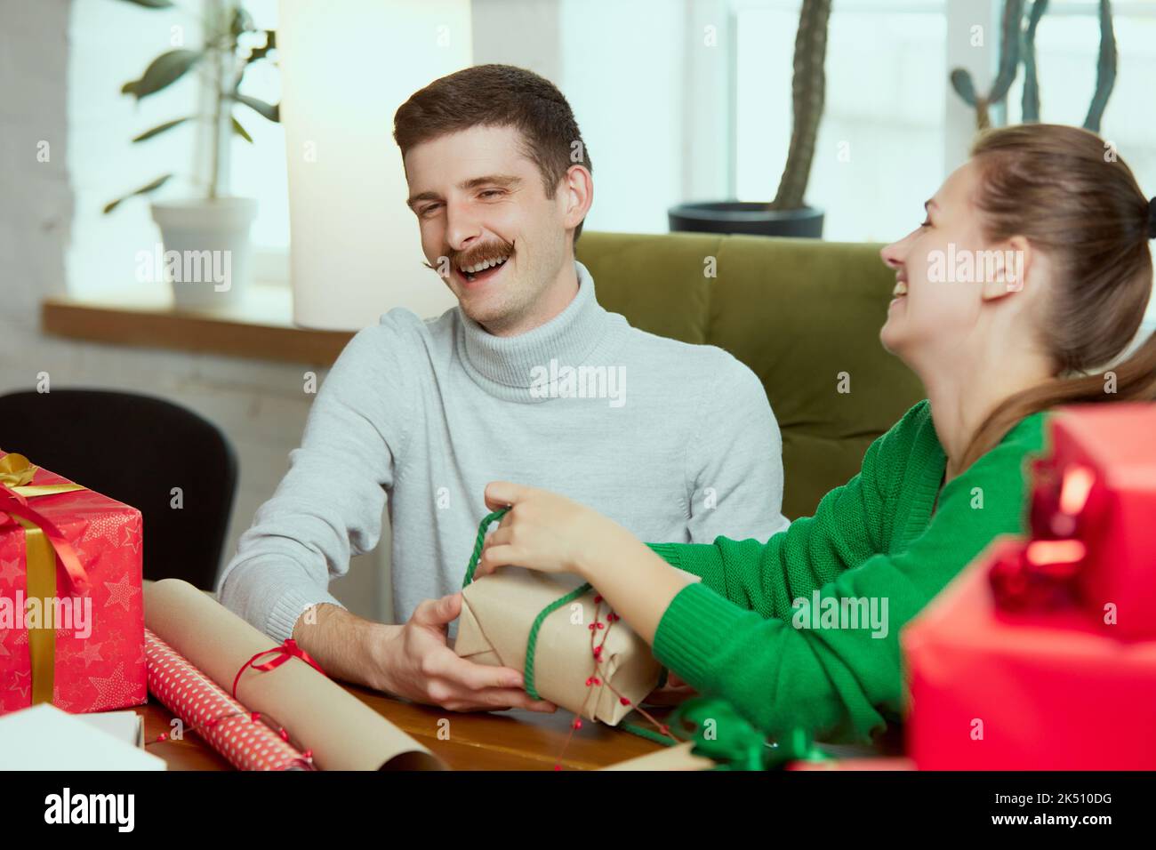 Portrait of cheerful young people, man and woman laughing and wrapping ...
