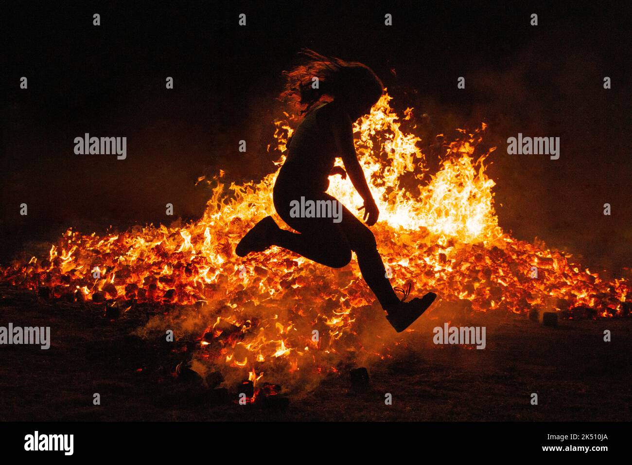 Summer solstice celebration jumping into the fire. Burning flames ...