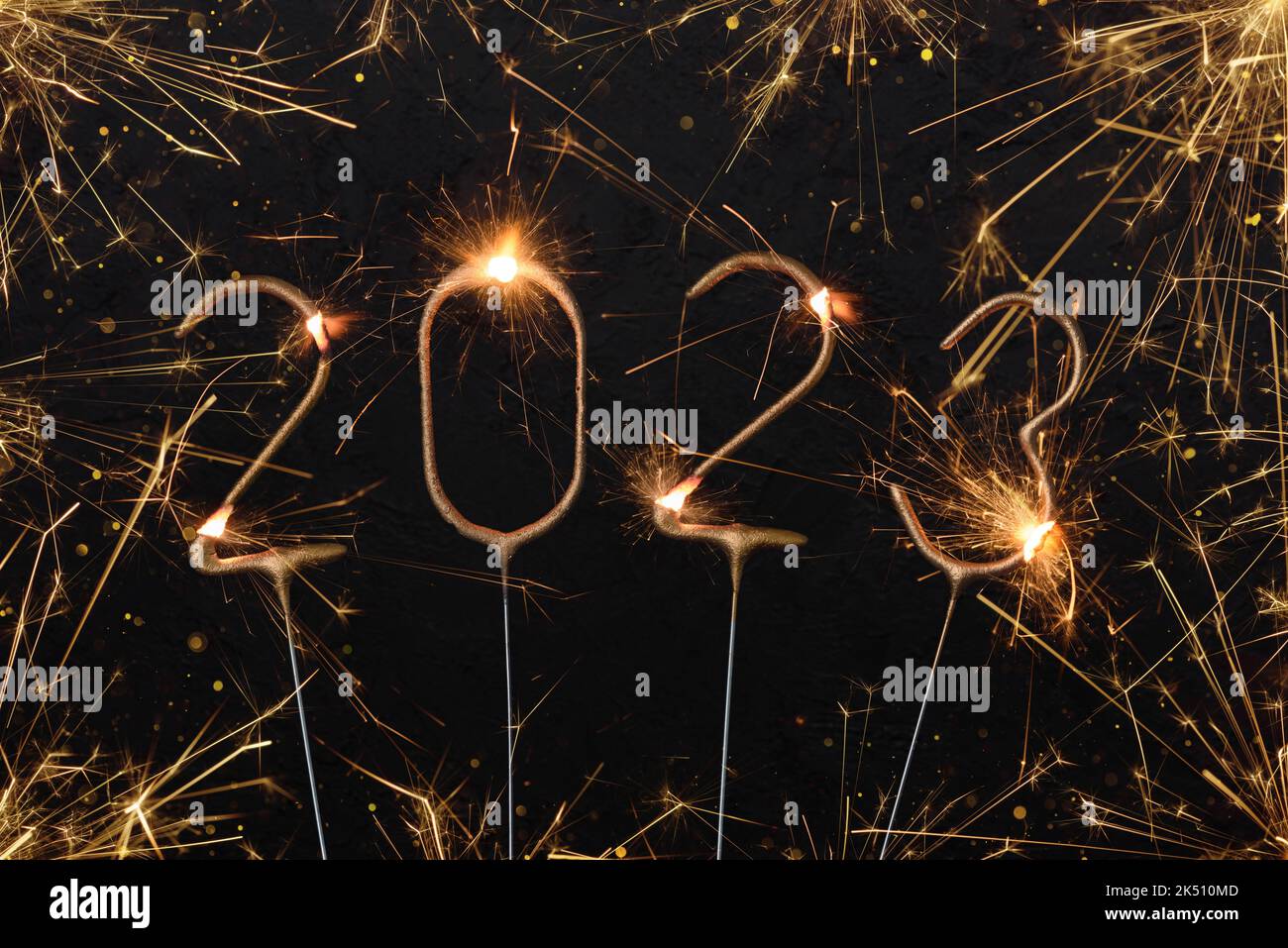 Happy New Year 2023 Silvester party card. Digits of year 2023 made by golden burning sparklers ...