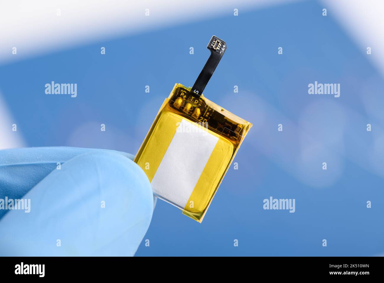 Scientist hold in fingers and show very small rechargeable lithium Li ...