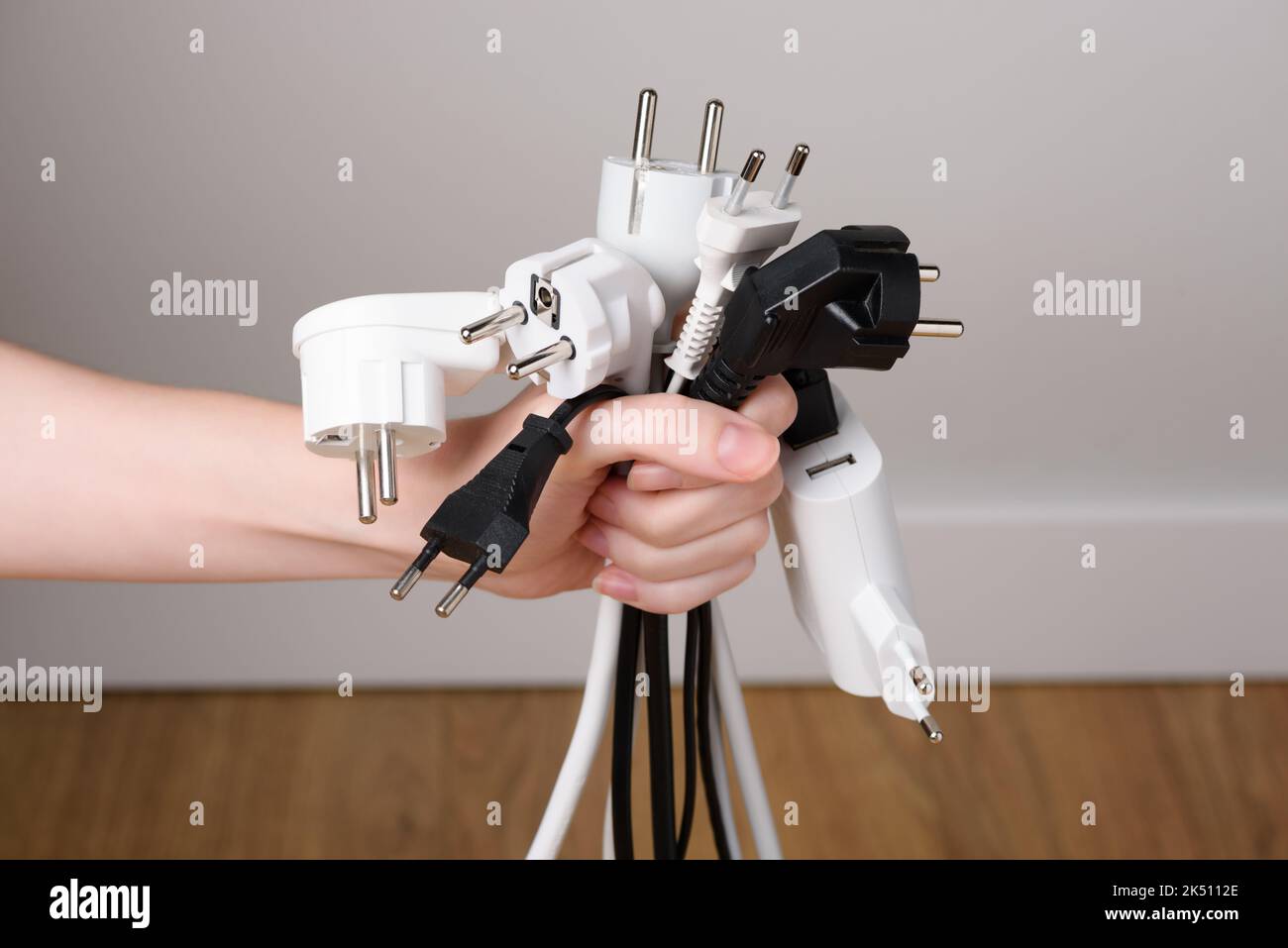 Hand holding bunch of electric plugs. Electric power consumption or ...
