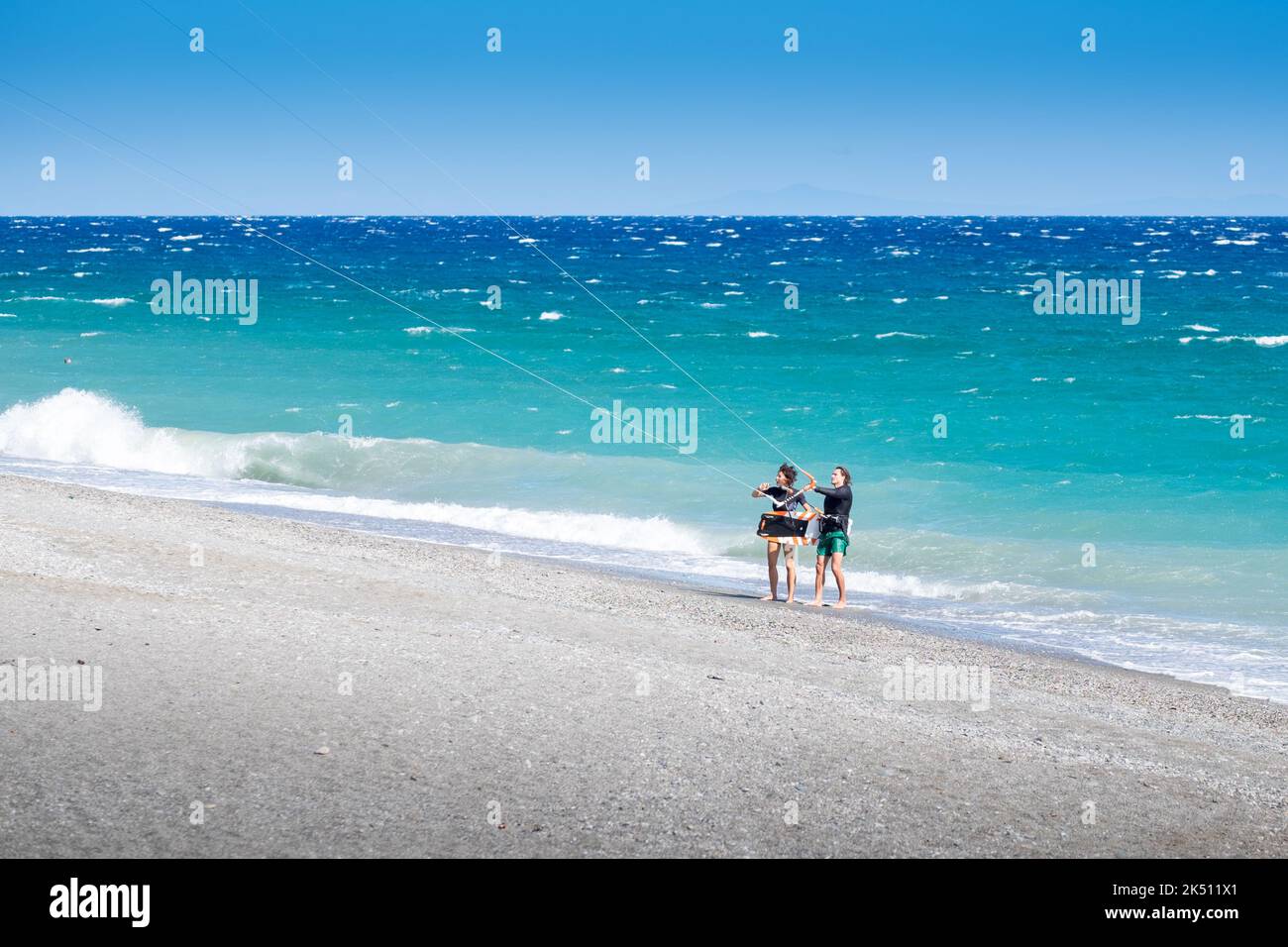 Kitesurfers controlling the kite at the shore of Agiokampos beach ...