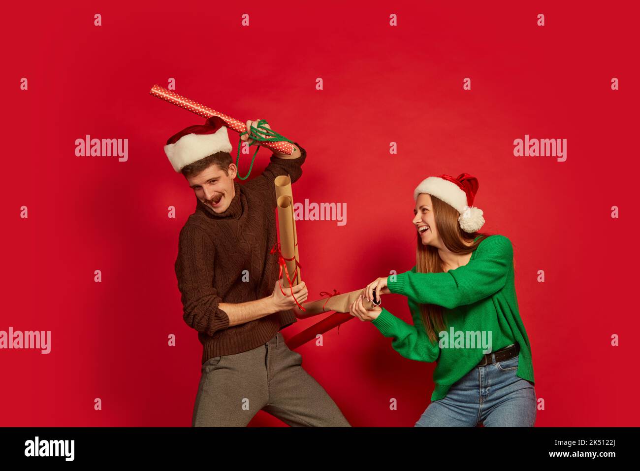 Portrait of cheerful young people, man and woman fighting in joy with ...
