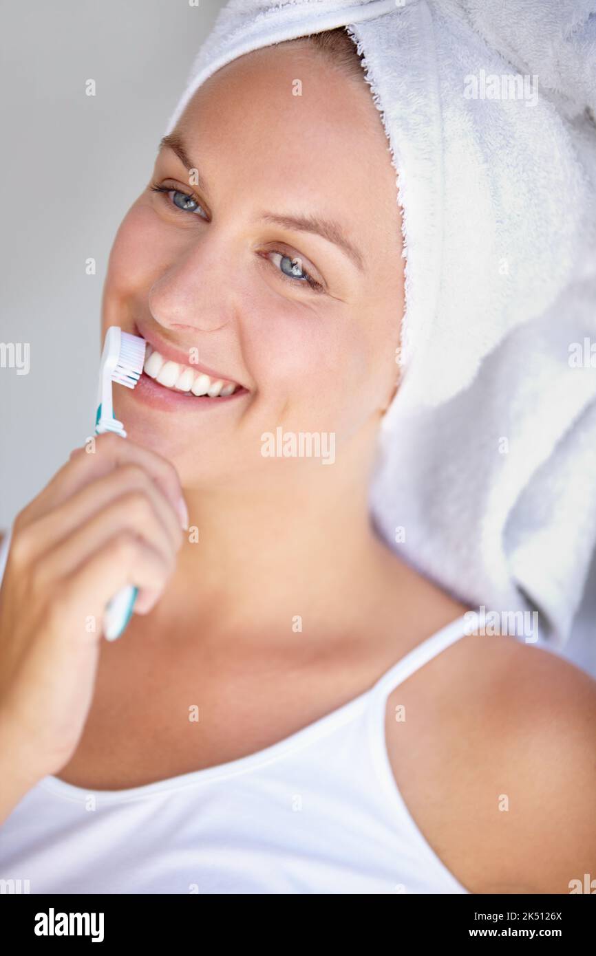 Maintaining the perfect smile. a beautiful woman brushing her teeth ...