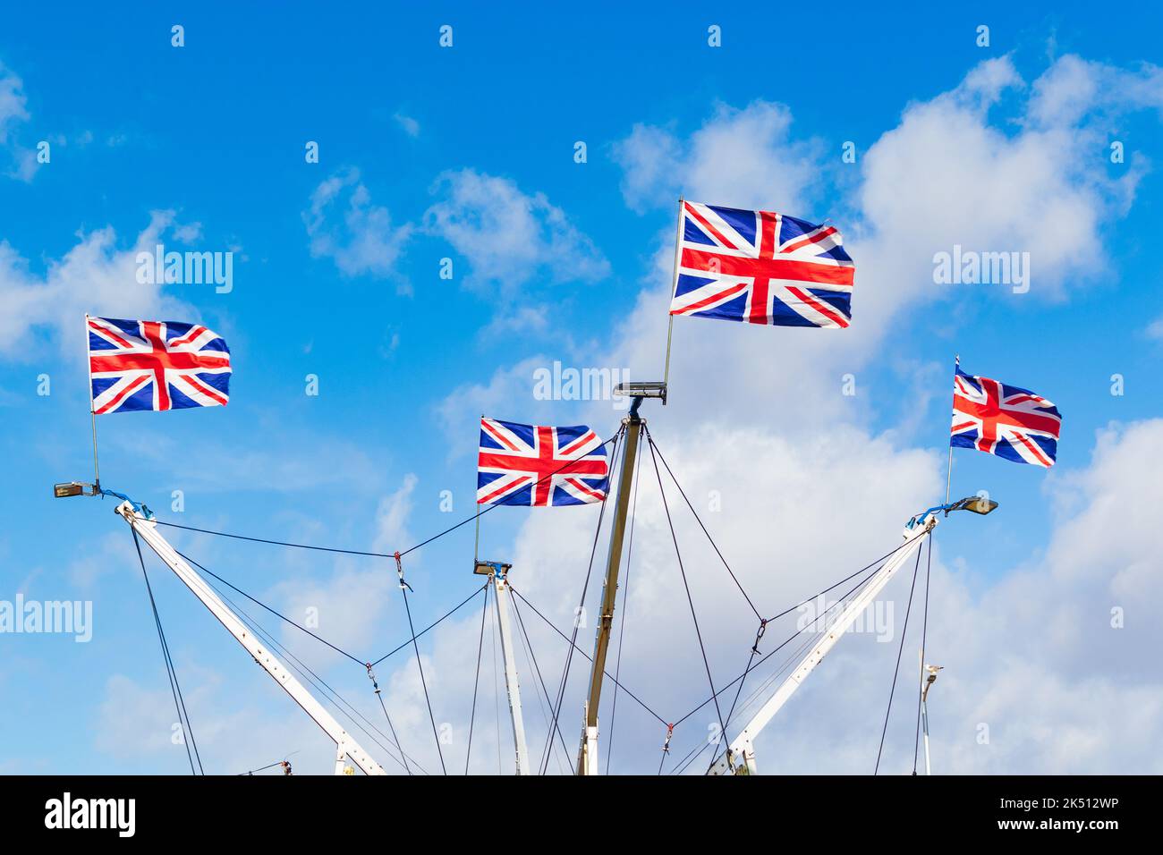 Four Union Jack, British flag waving in the wind on a platform at ...