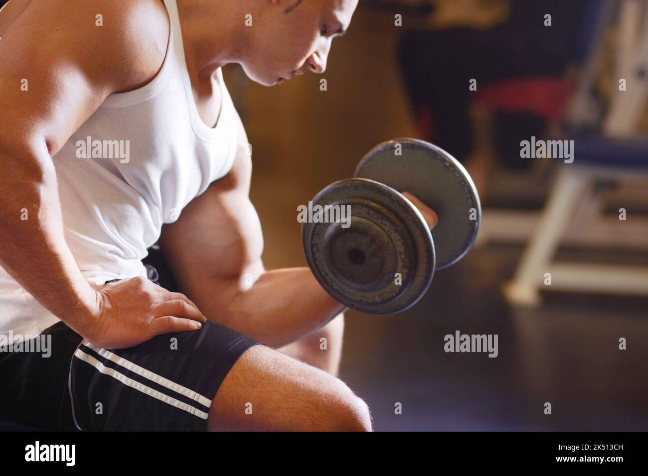 Proof that hard work pays off. a handsome young man lifting weights ...