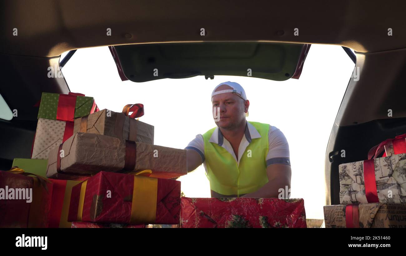 delivery service. deliveryman loads boxes. gift boxes in car ...