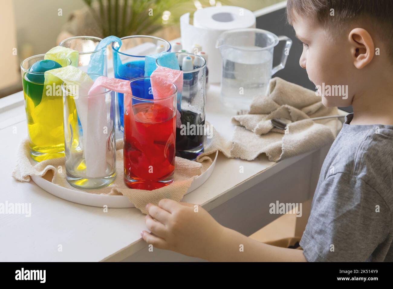 Cute baby boy learning mixing different colors with water and paint in ...