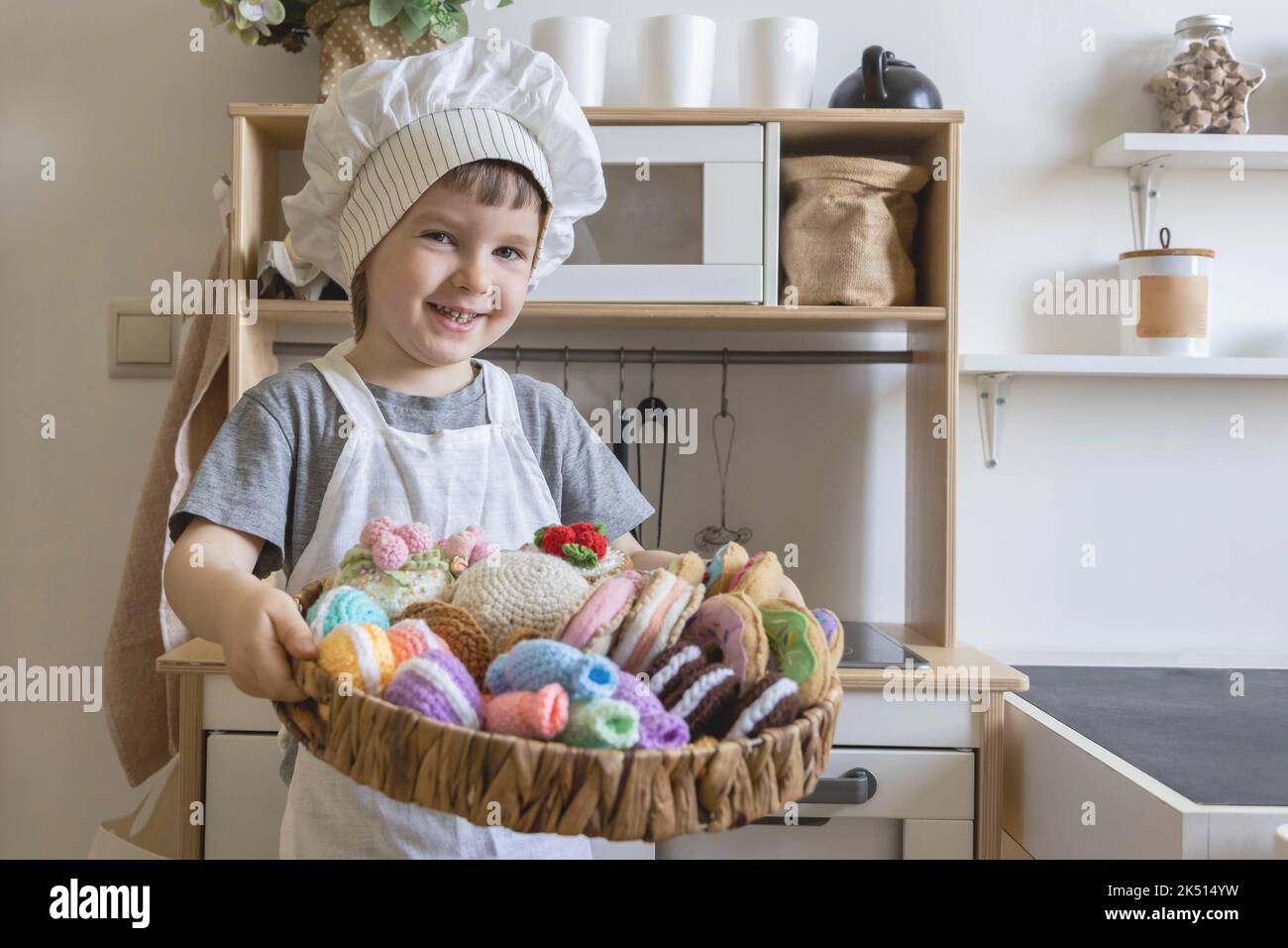 Cute little baby boy in chef hat and apron playing at childish kitchen ...