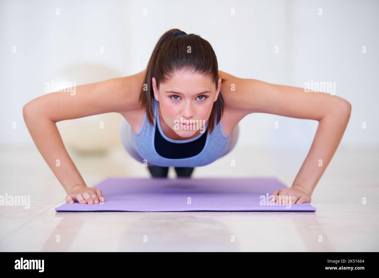Upper body workouts. Portrait of an attractive young woman doing push ...