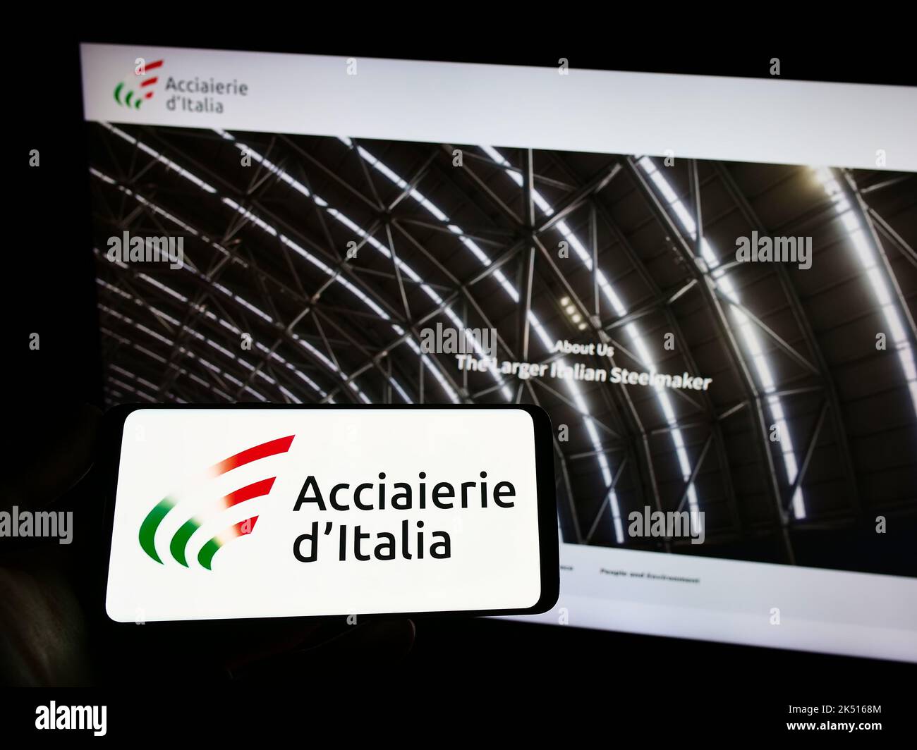 Person holding smartphone with logo of Italian steel company Acciaierie ...