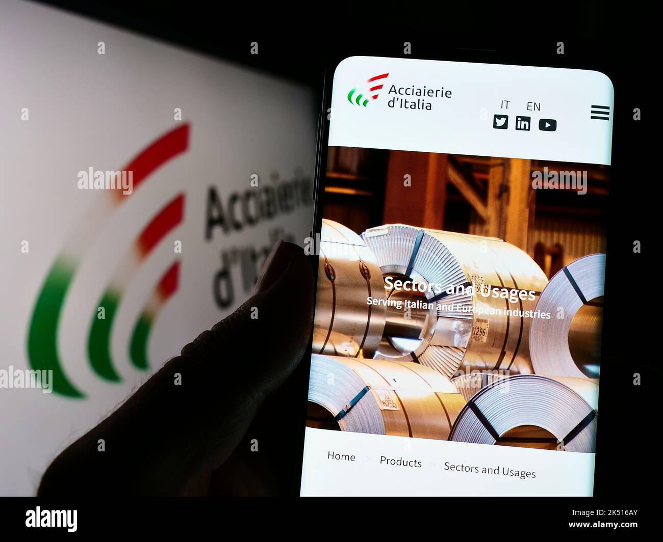 Person holding mobile phone with website of Italian steel company ...