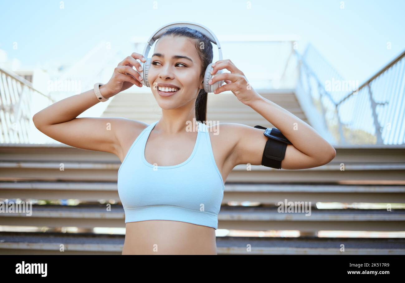 Fitness, healthy and young woman listening to music on a wireless headset while training ...