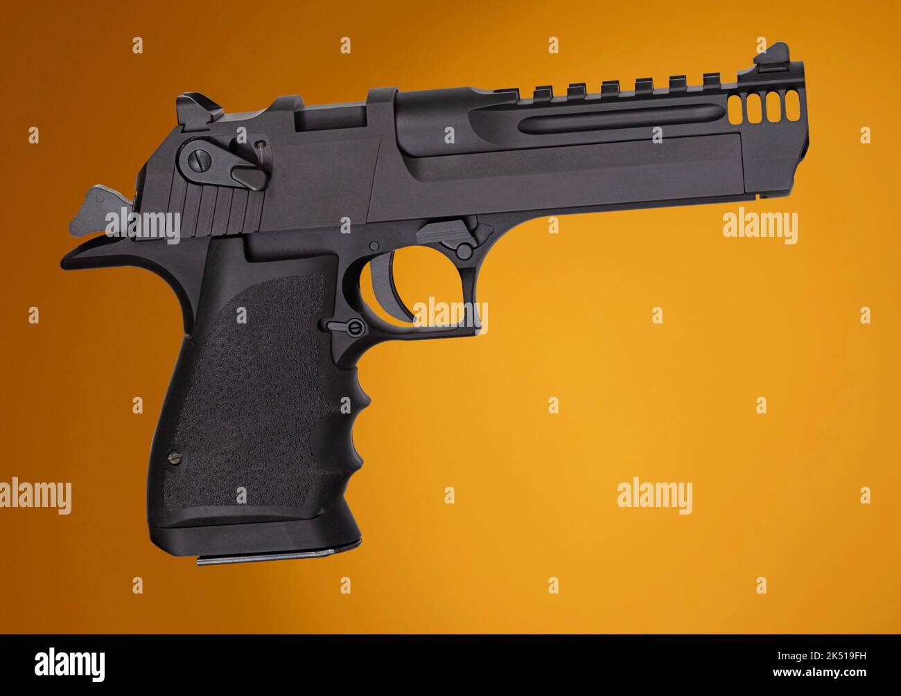 Side view of a large caliber semi-automatic pistol on a beige and ...