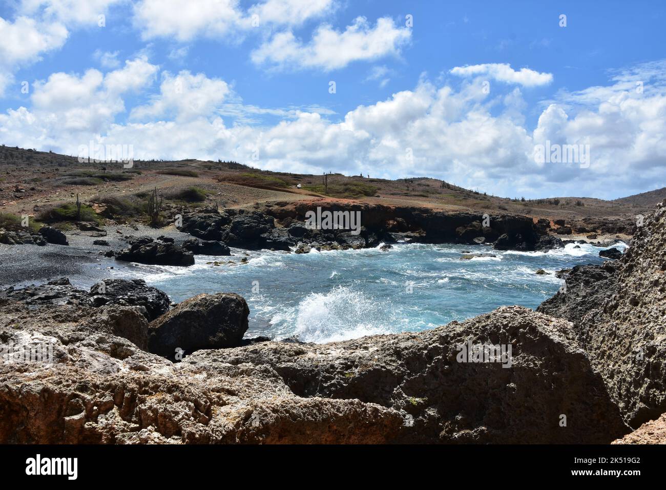 Coastal cove with waves splashing and crashing on the lava rock in ...