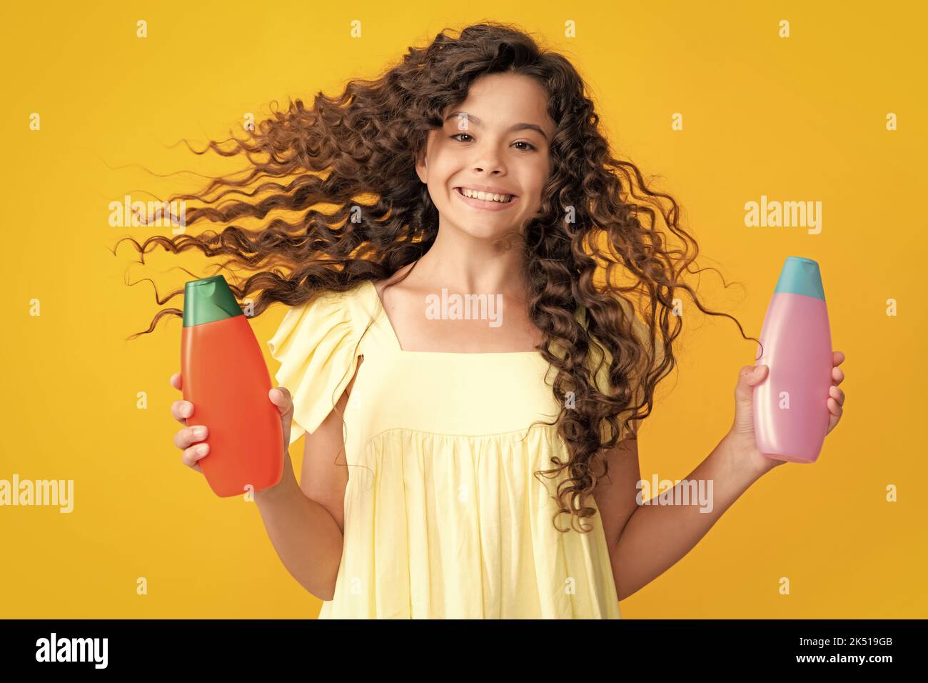 Teenager child girl showing bottle shampoo conditioners or shower gel ...