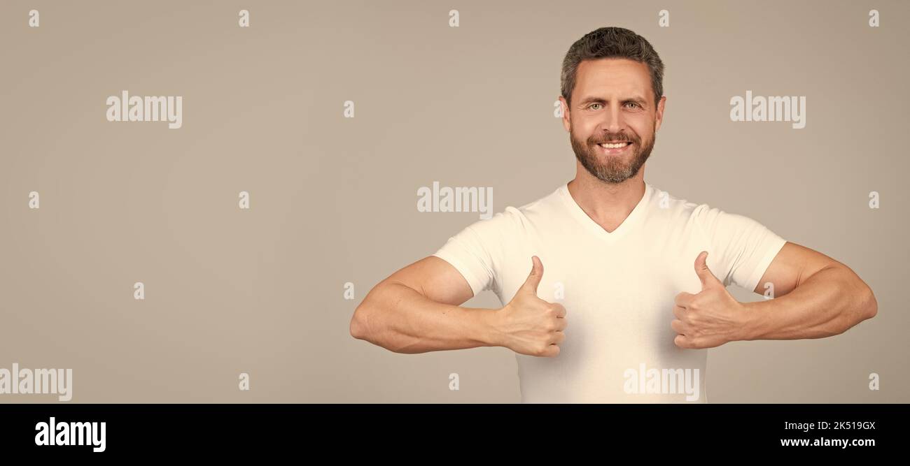 Double thumbs ups. Happy man give thumb sign. Handsome guy show thumbs ...