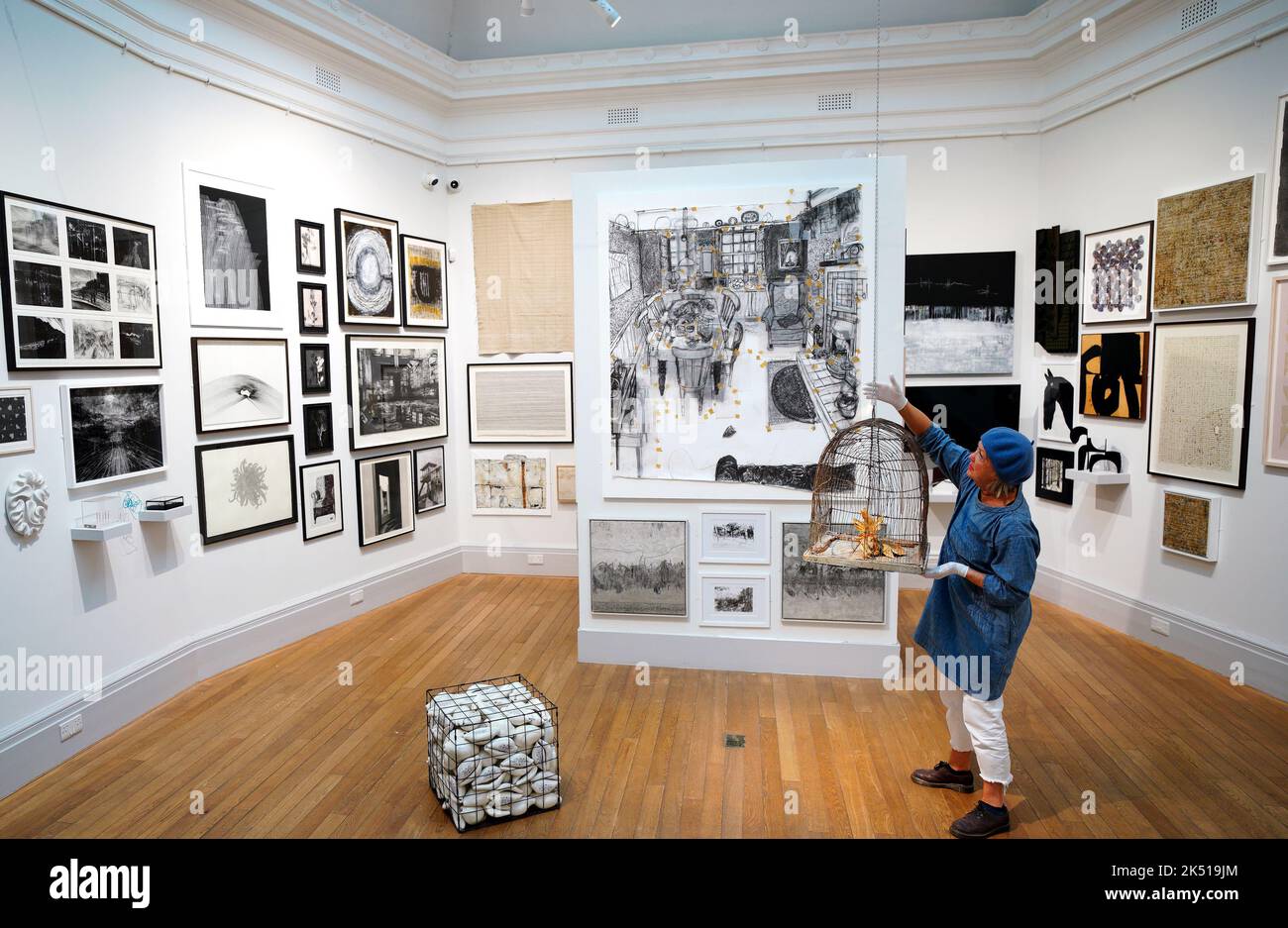 Gallery technician Karen Holbrook looks at an artwork called 'Encaged' by Artist Anna Gillespie ...