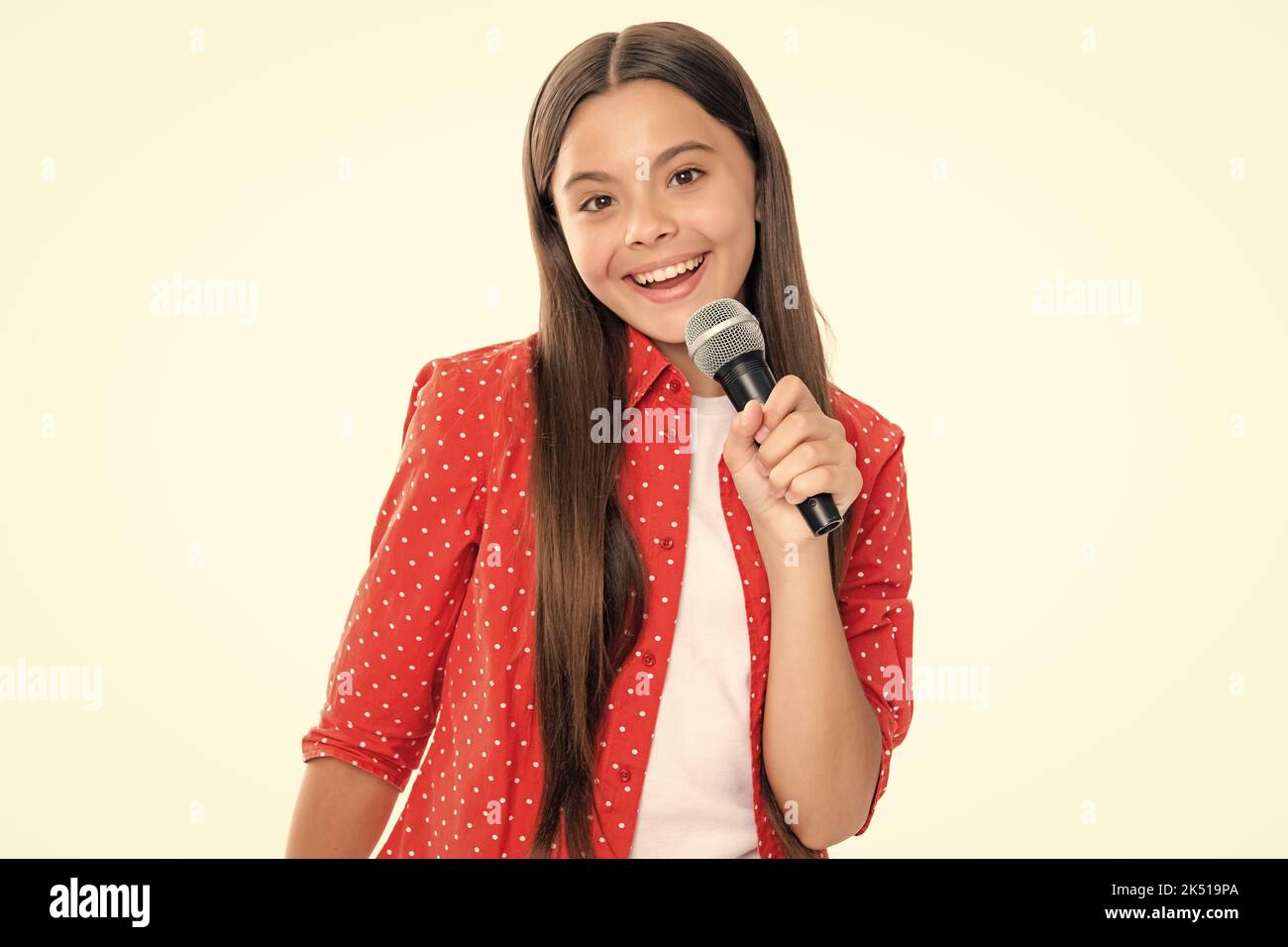 Child girl holding wireless microphone for karaoke singing or talk and ...