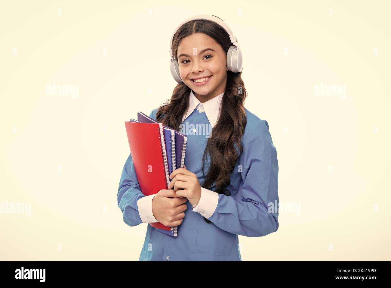 Teenager school girl wearing headphones reading a book over isolated ...