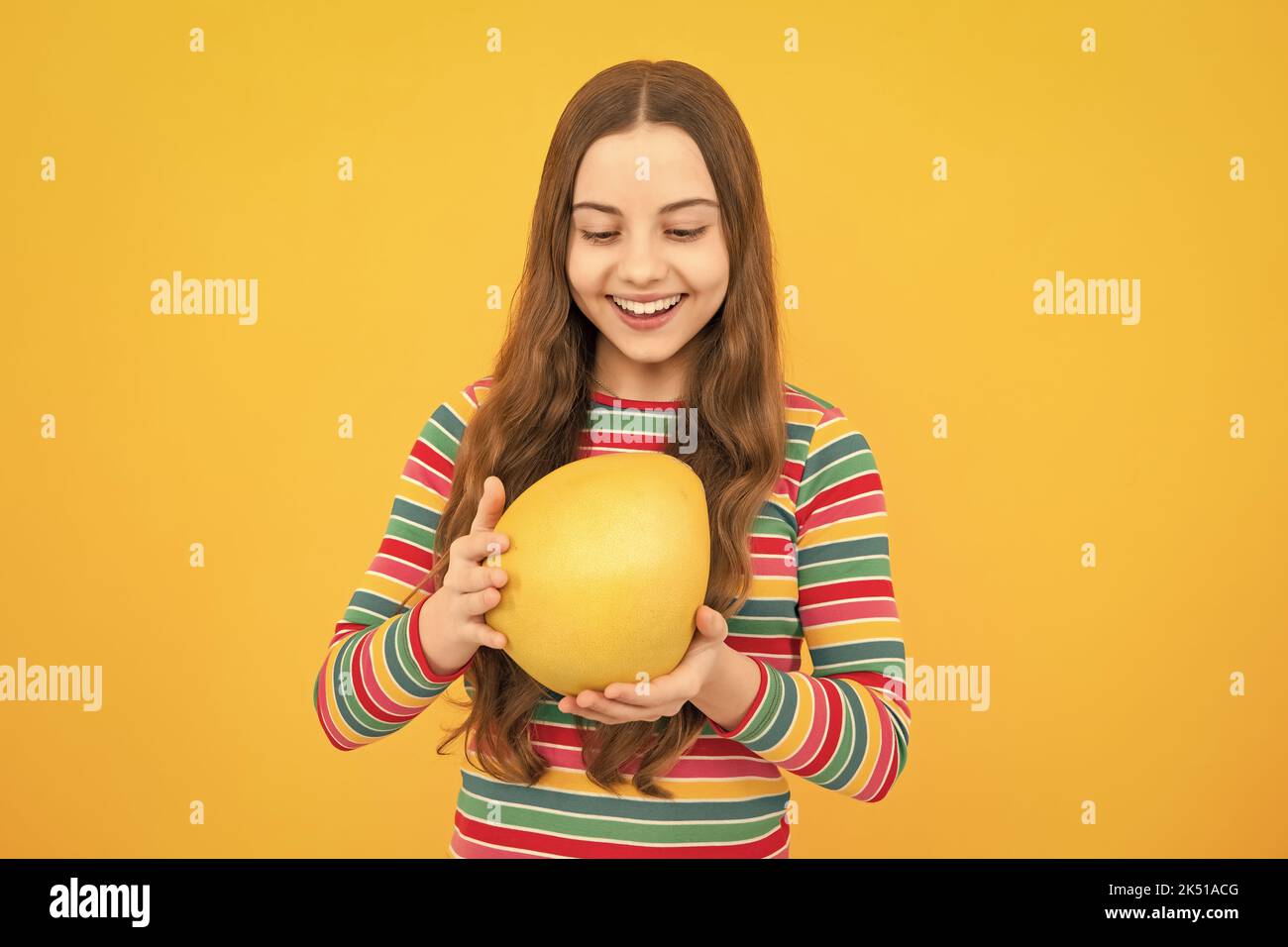 Teenager child girl hold citrus fruit pummelo or pomelo full of vitamin ...