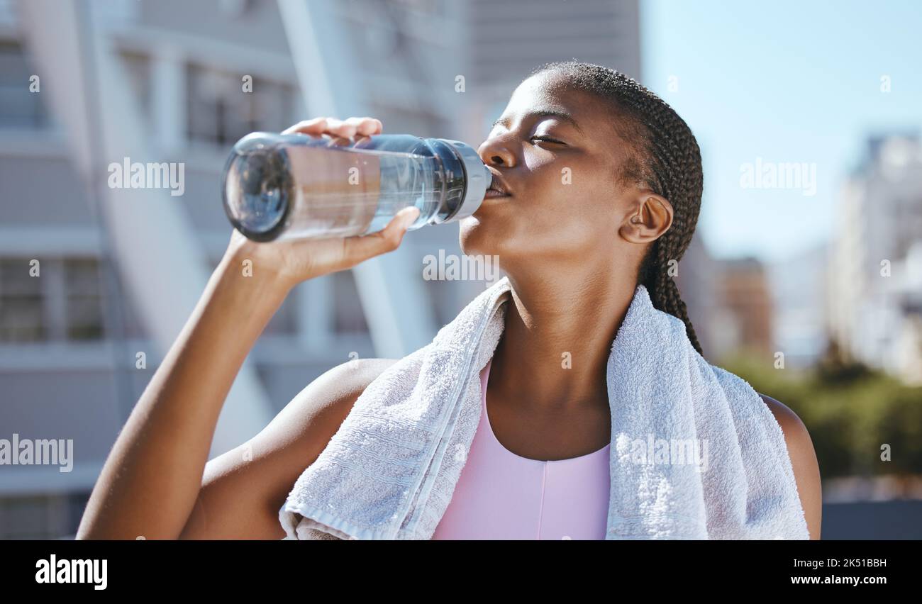 Fitness, exercise and black woman drinking water after running ...
