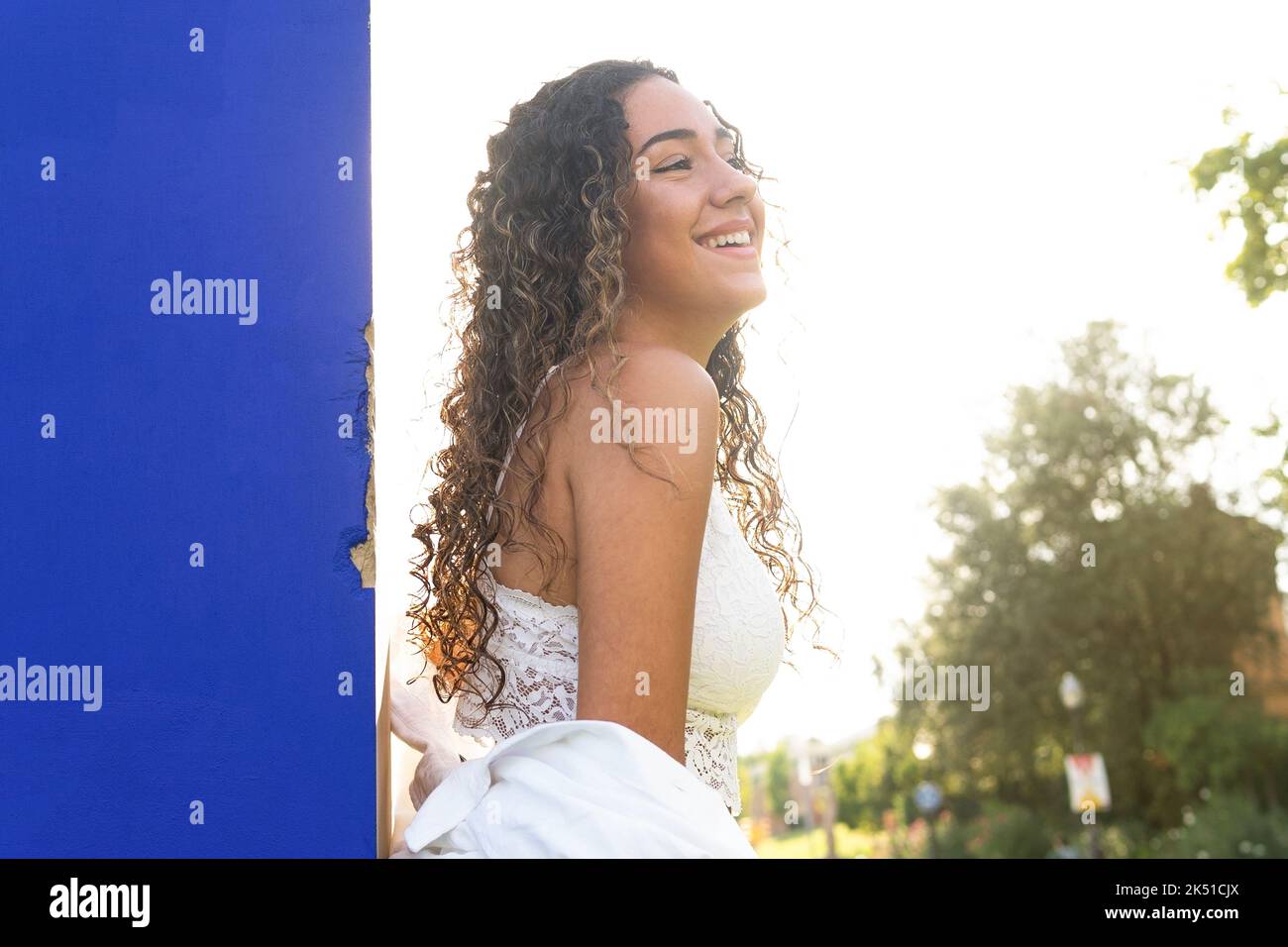 Low angle side view of cheerful young Hispanic woman in white lace bra ...