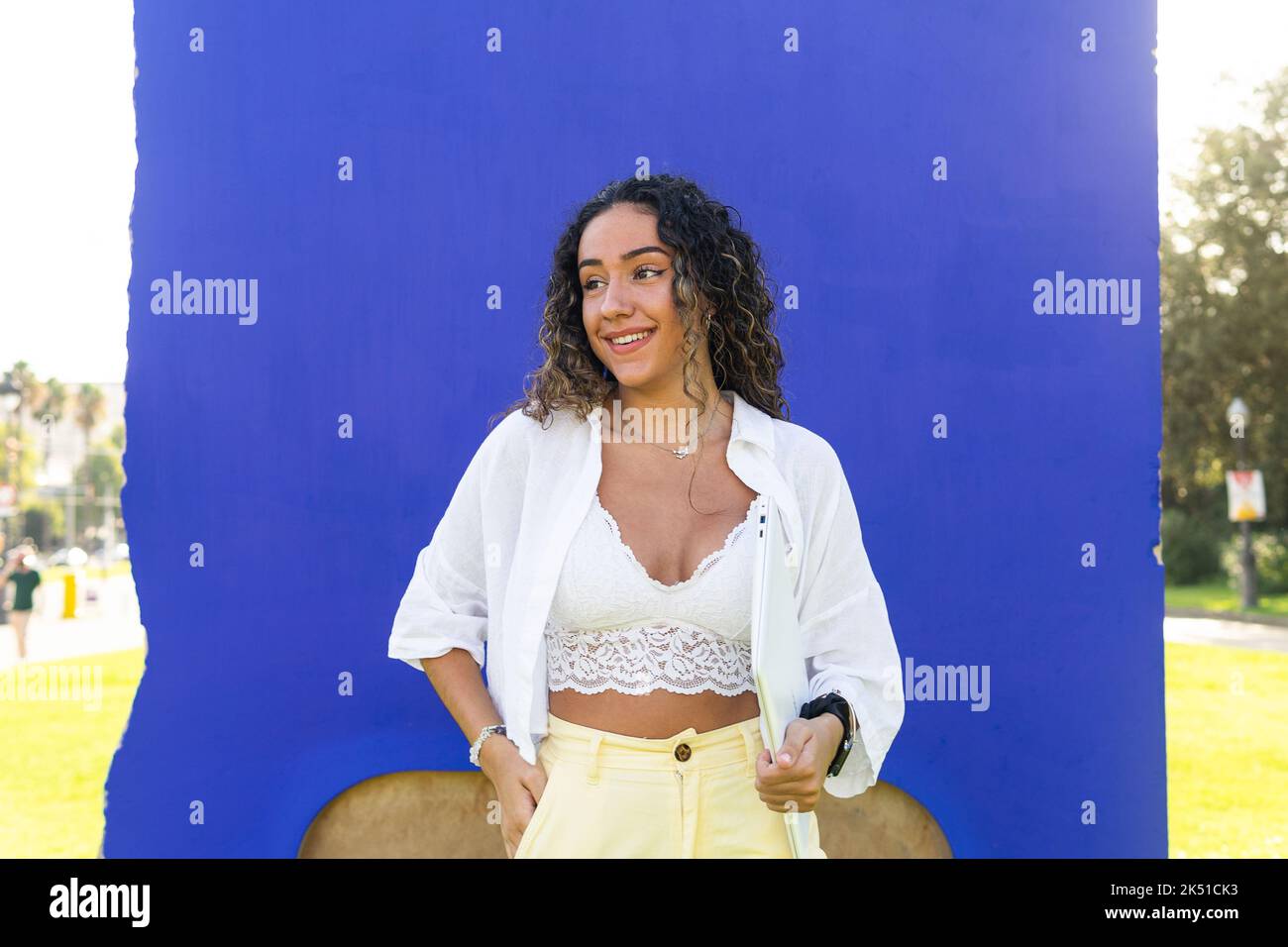 Low angle side view of cheerful young Hispanic woman in white lace bra ...