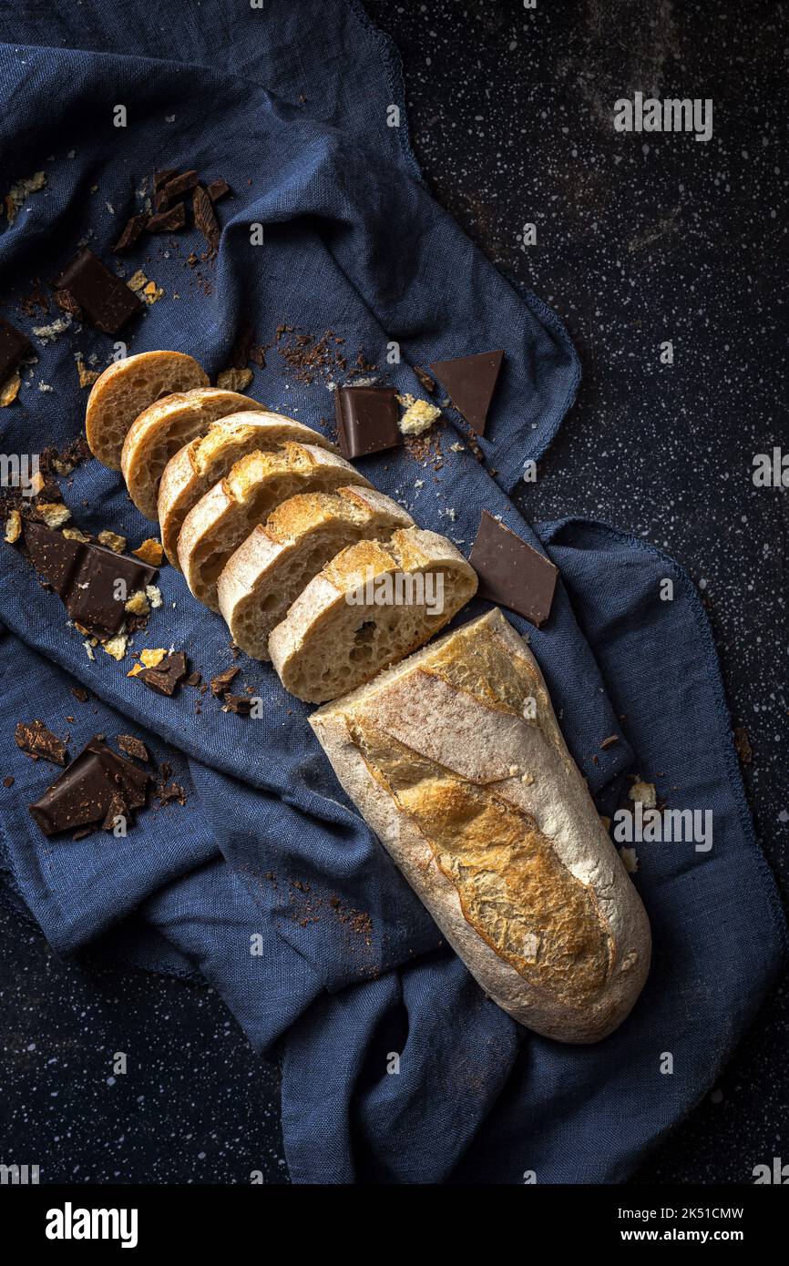 High angle of freshly baked cut bread loaf with chocolate bars placed ...