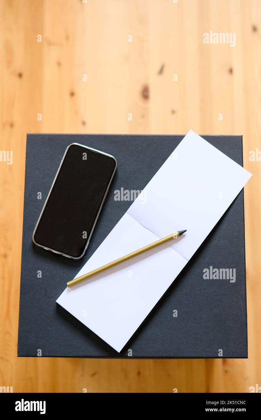 Top view of cellphone with black screen placed on cardboard box near ...