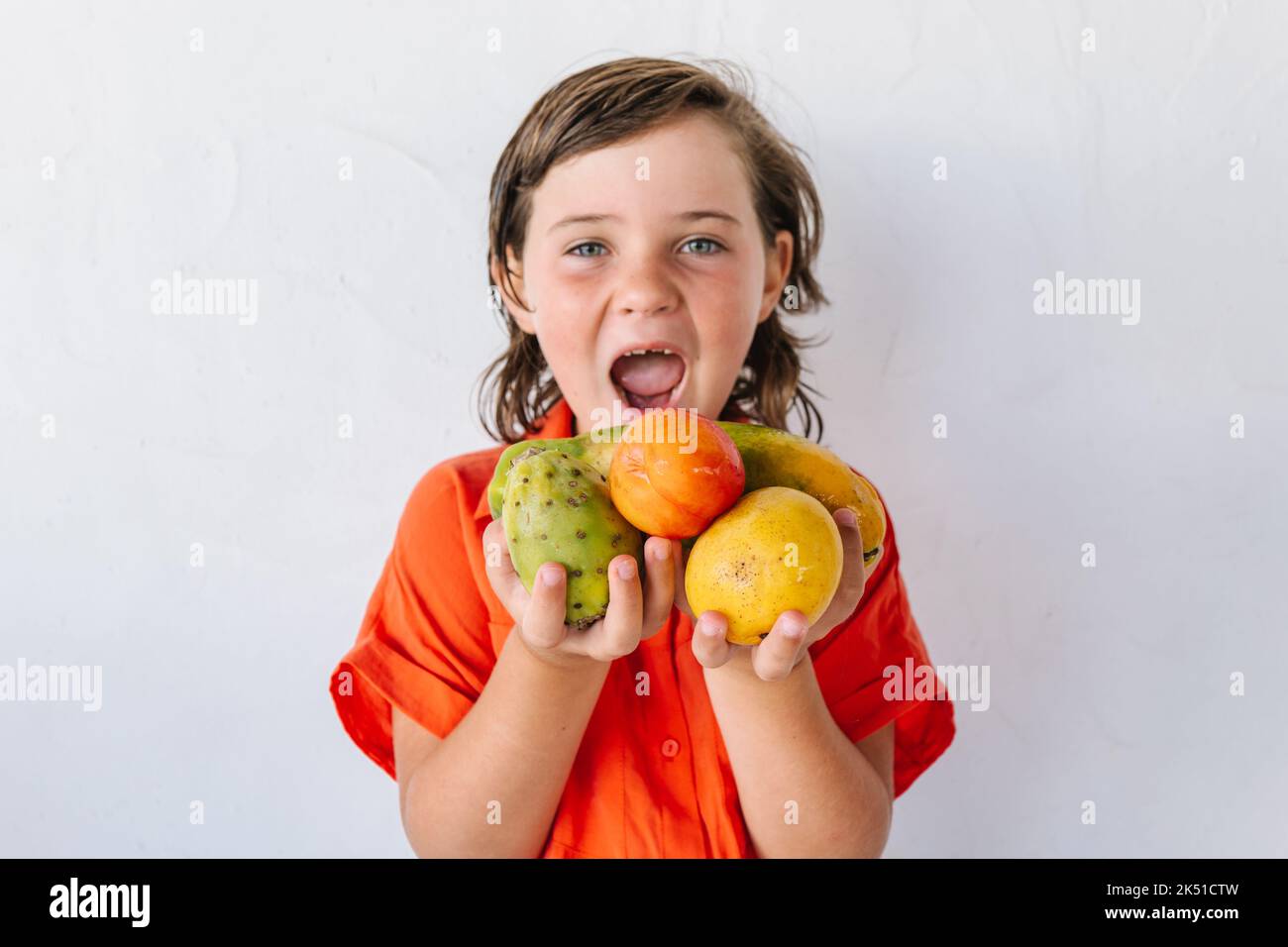Adorable little boy in bright red shirt screaming happily and looking ...