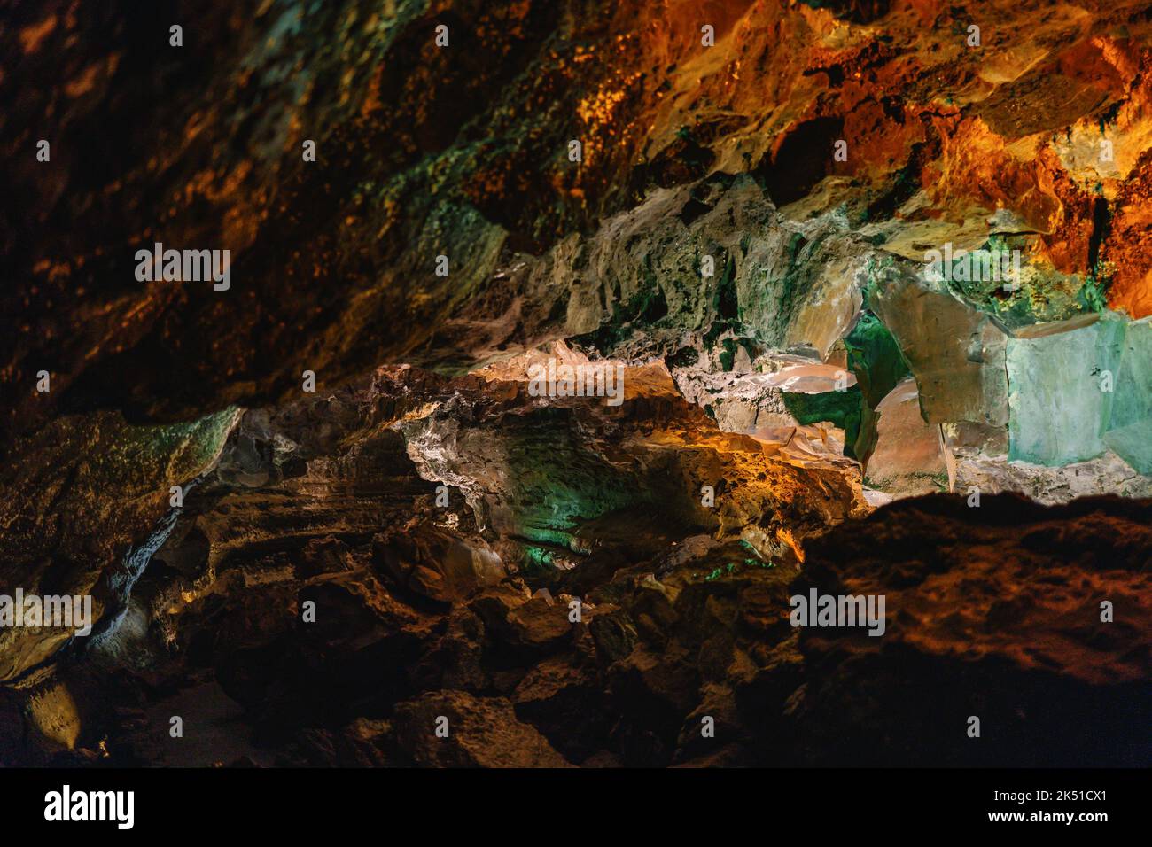 Crystal stalactites of emerald color hanging from rough ceiling of ...